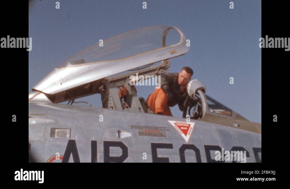 1950s: Pilot climbs into cockpit of Air Force fighter jet. Pilot dons ...