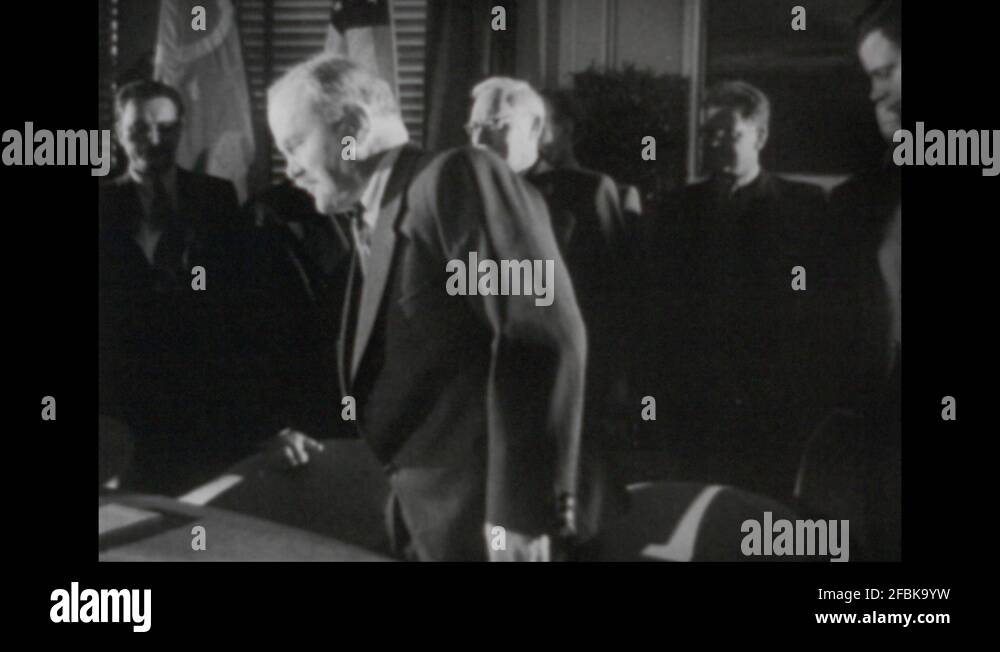 1940s: Men sit down around large round table in meeting room. Men sit ...