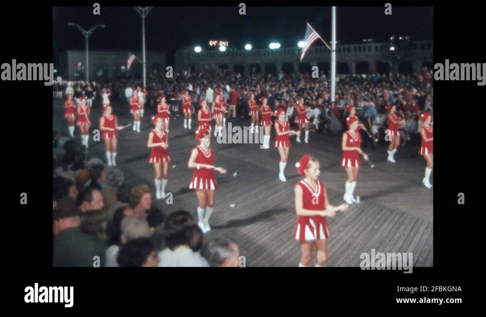 1970s: Cheerleaders march and wave batons in parade. Pageant winner ...