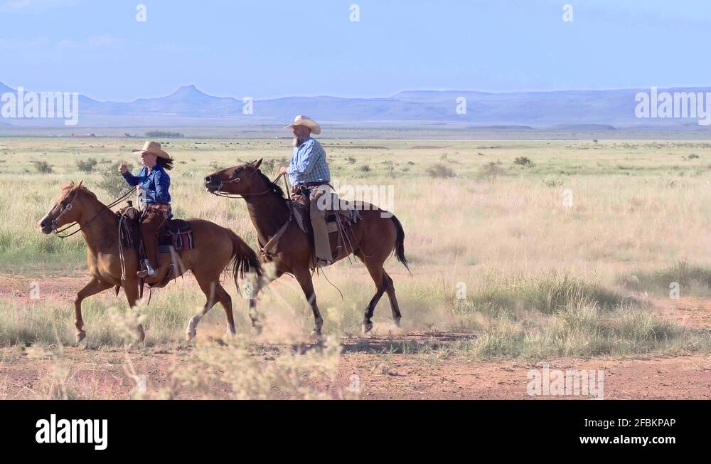 Rotation view of a man and woman riding horseback together in Texas ...