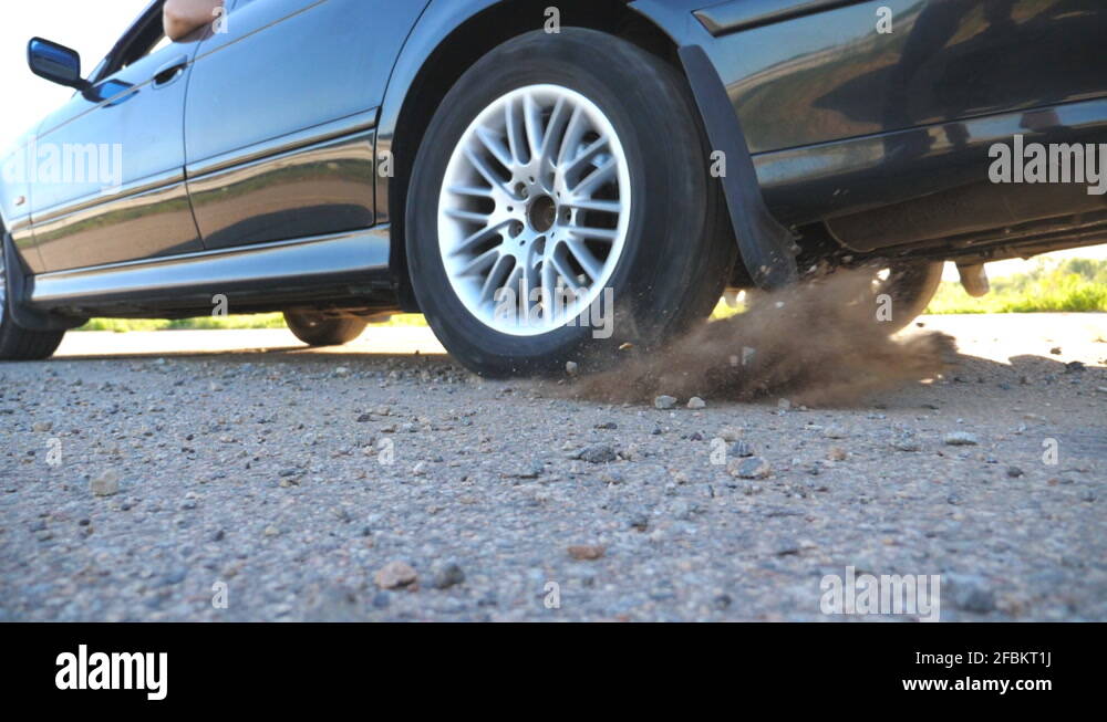 Wheel of car are slip on a asphalt road during start of movement. Slow ...
