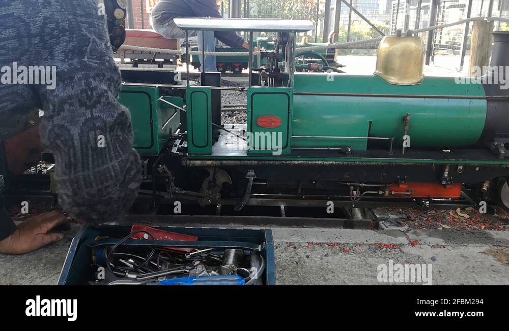 A mechanic working on a fully functional scale miniature steam ...