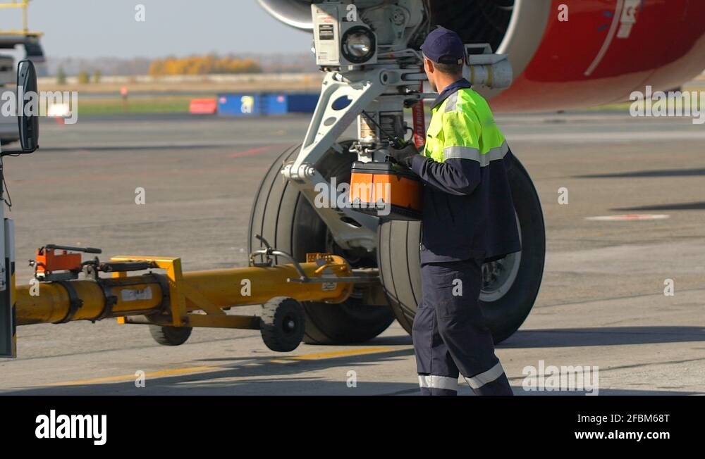 Airport airplane mechanic, worker technical staff towing tow tractor ...
