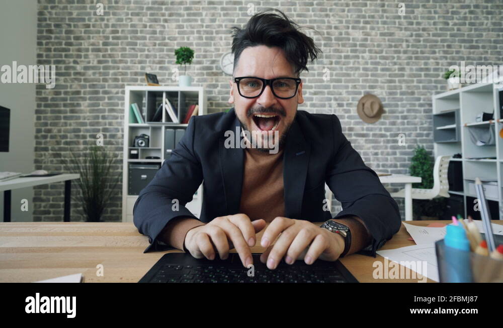 Mad office worker typing touching keyboard looking at camera in ...