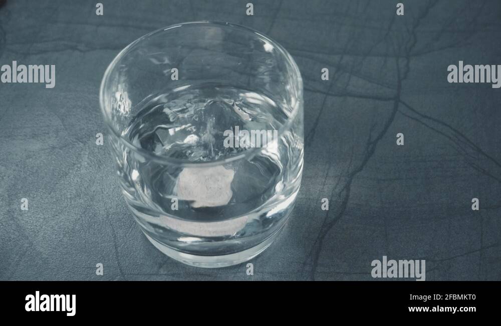 fallin effervescent calcium tablet dissolve slow motion in a glass with ...