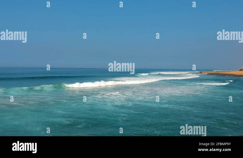 Flying drone over the Beach/Sea shoreline above the sea and sand at ...