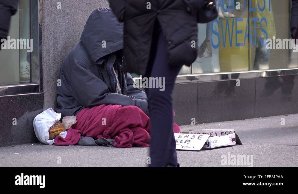 Person with a please help sign sitting on side walk in NYC 4k Stock ...