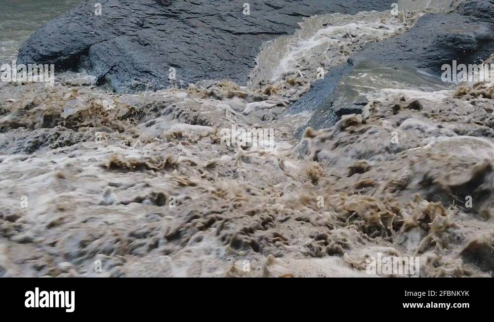 Dirty river water after the flood, rapid stream early spring after a ...