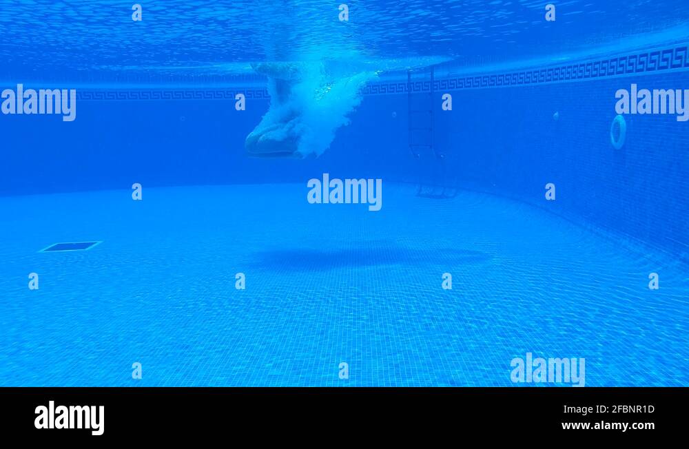 Underwater shooting as a man dives into the pool and swims under the ...