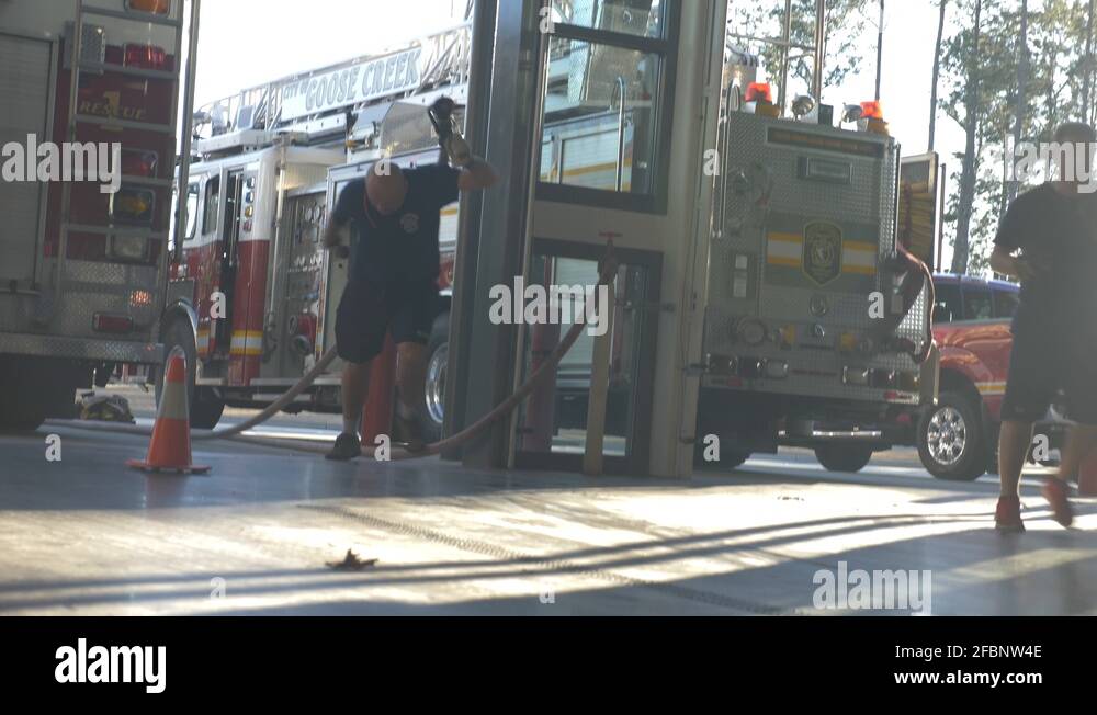 Firefighter pulls fire hose during a firefighting emergency training ...