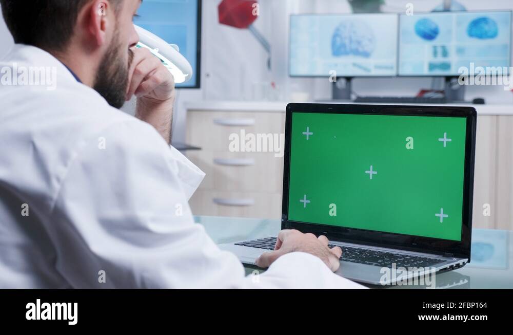 Static over the shoulder shot of medical staff working on green screen ...