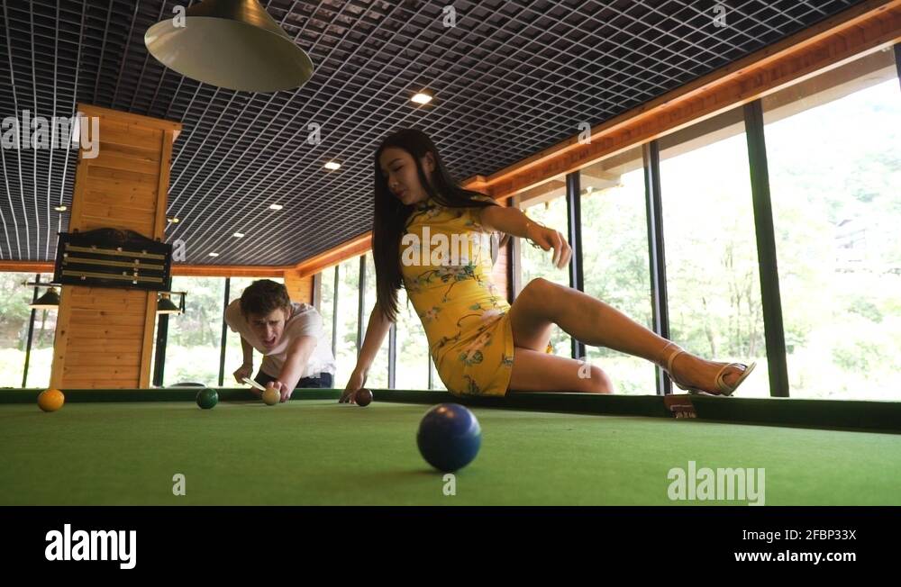 Beautiful Asian Woman Seductively Sits On The Side Of A Billiards Table