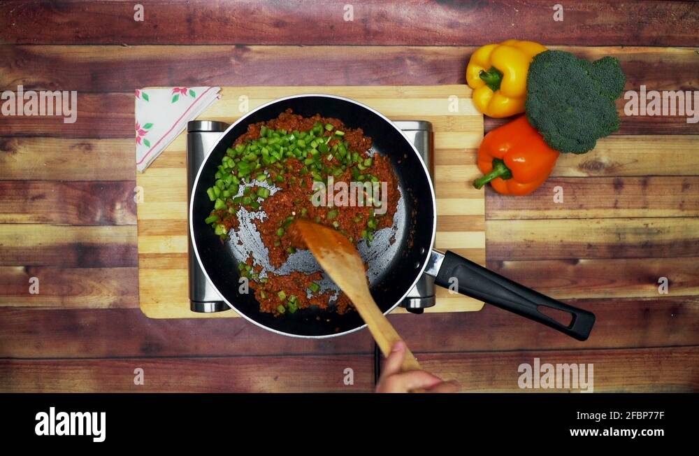 A Top view of mixing the ingredients in pan, placed on a stove, two big ...