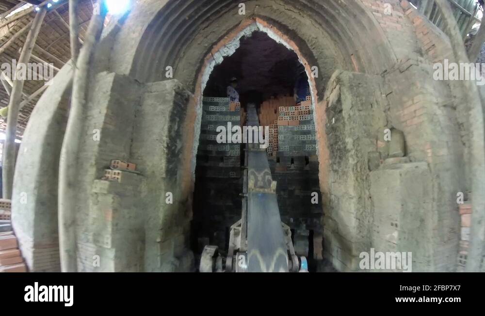 Vietnamese brick making factory with workers using a conveyor belt to ...