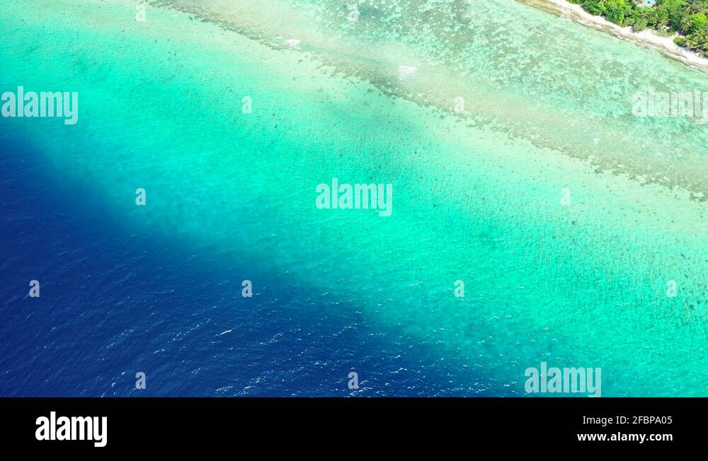 Looking down while flying above a water divide in the Maldivian Sea ...