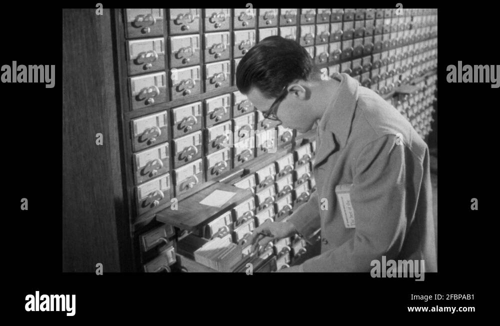 1950s: Man flips through card catalog. Men walk through library, study ...
