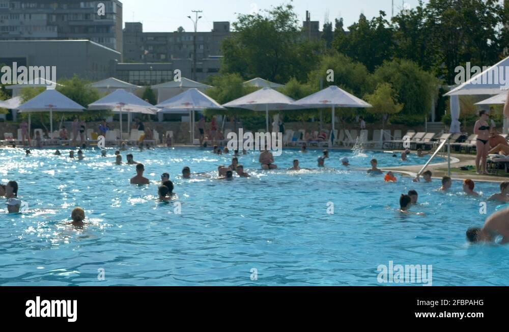 People crowd chilling in water park swimming pool during hot summer day ...