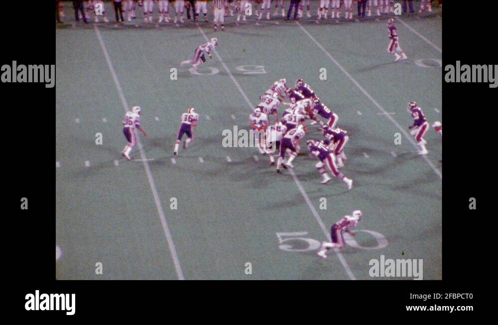 1970s: Football field. Teams at the 50 yard line. Quarterback runs with ...