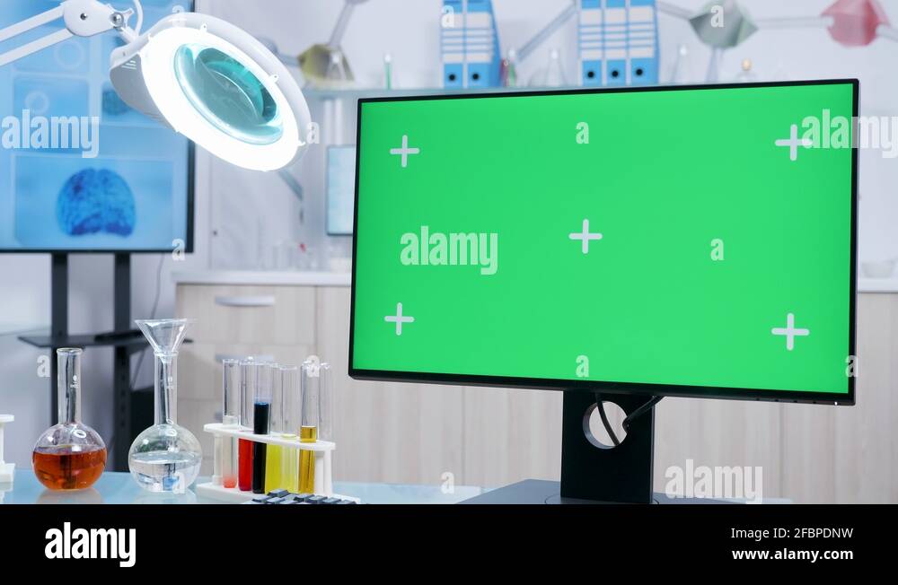 Static shot of chemist desk with a green screen mock-up desktop PC ...