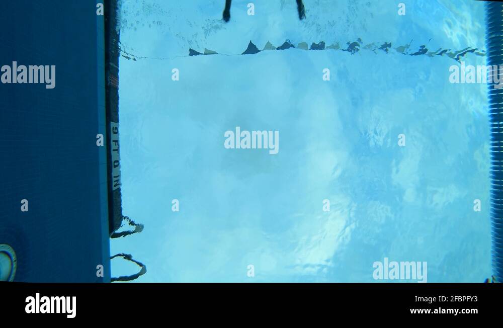 Underwater angle of a female swimming smoothly through her lane of a ...