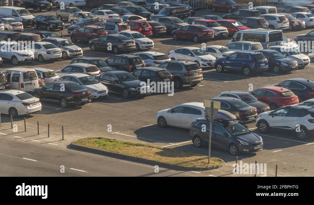 Cars leave the extensive open Parking lot at the end of the working day ...