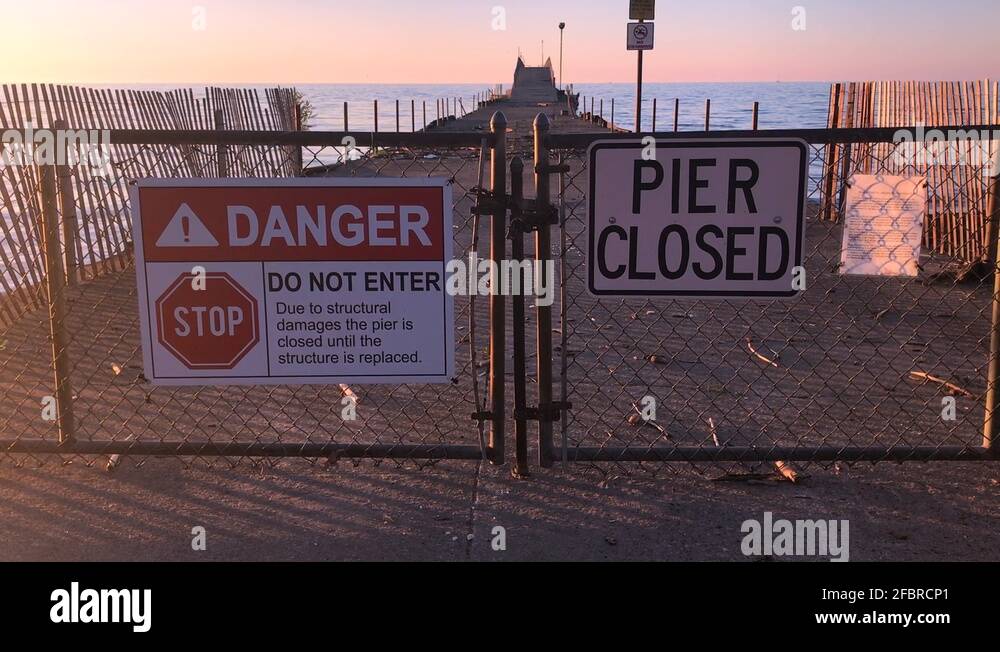 Pier closed signs of danger where a beach is not safe and falling into ...