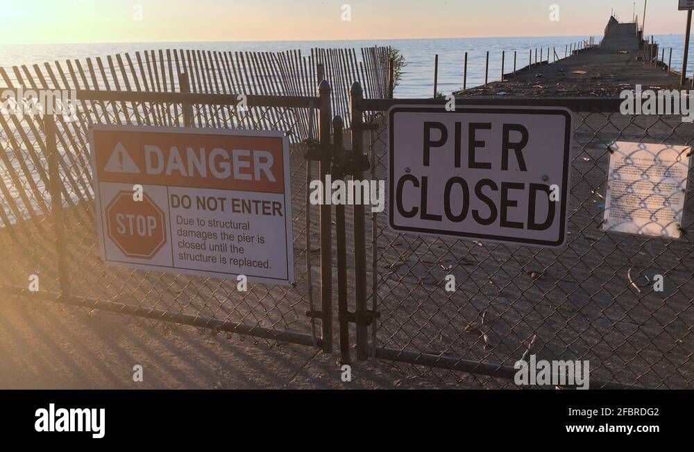 Pier closed signs of danger where a beach is not safe and falling into ...