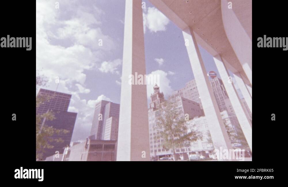 1960s: Tilt up columns, pan to building entrance. Low angle pan of ...