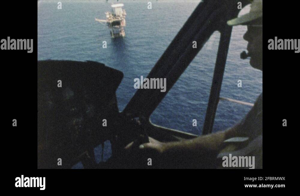 1960s: UNITED STATES: pilot flies helicopter to offshore production rig ...