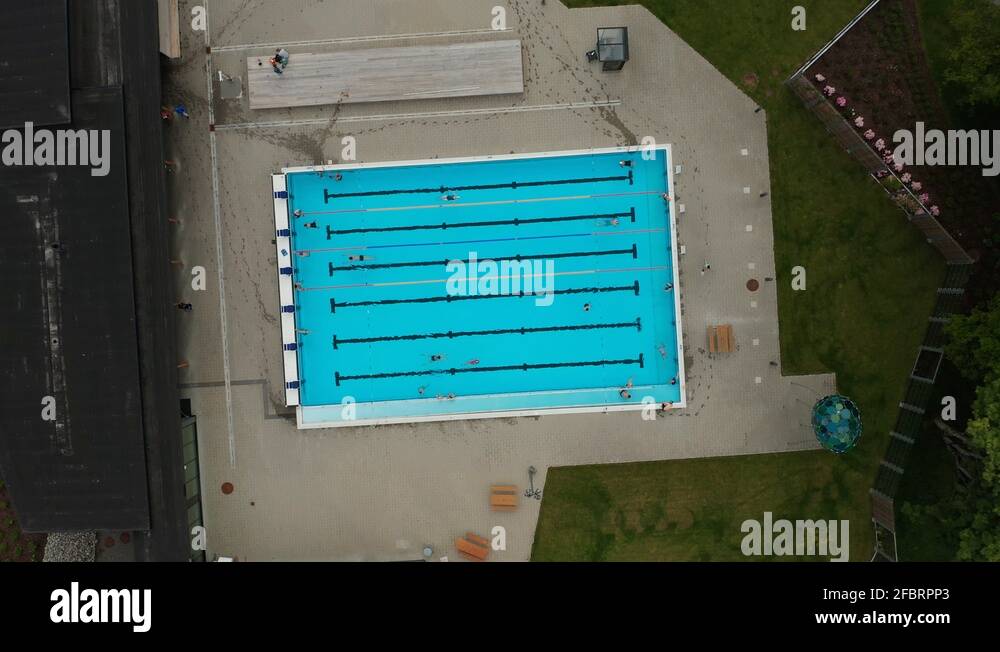 Cinematic Rotating Aerial of Public Swimming Pool With Swimmers in ...