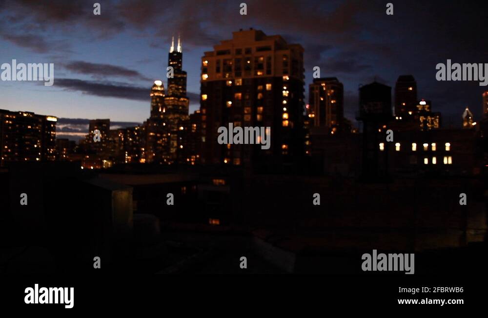Man walking and smoking cigarette on rooftop in city during sunset ...
