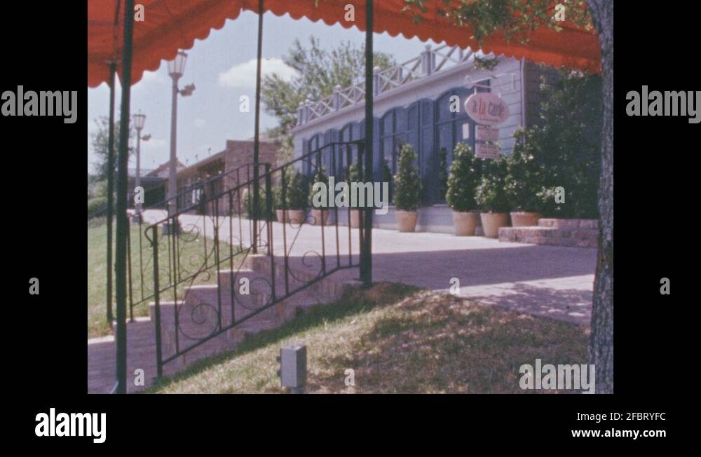 1960s: Exterior of building, people walk up steps, walk past building ...