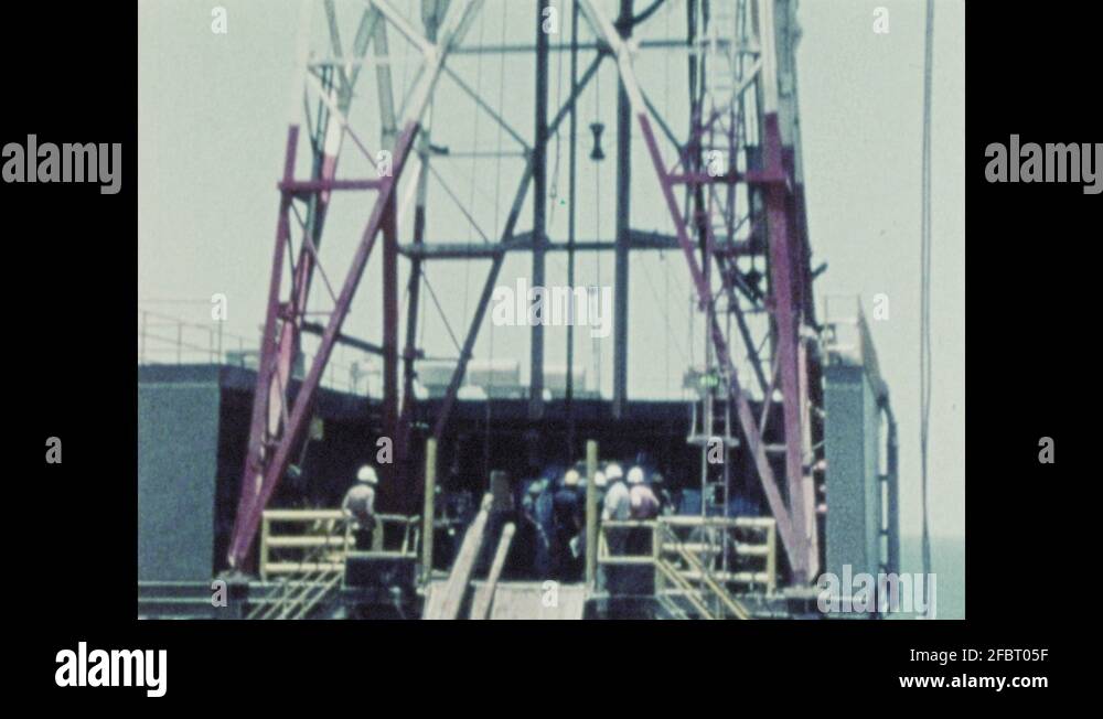 1960s: UNITED STATES: drilling of exploratory well. Men work with drill ...