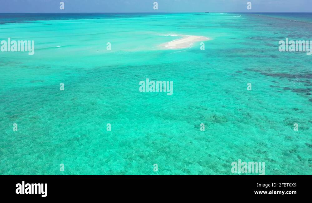 A small isolated sand beach island is resting on the reef in the Stock ...