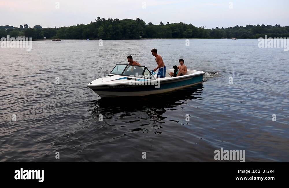Video of a group of shirtless friends on a motorboat speeding away on a ...