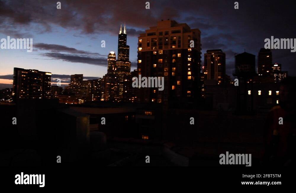 Man walking and smoking cigarette on rooftop in city during sunset ...