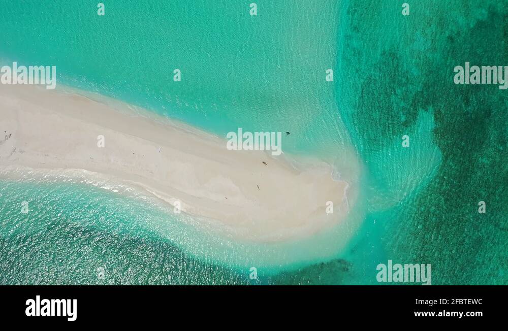 Drone zoom in over a small white sand beach island in the Philippines ...