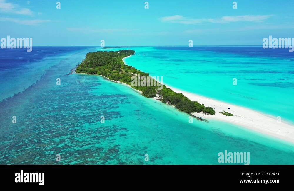 Drone footage of a long and narrow island in the Maldives Islands, with ...