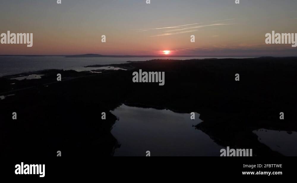 Drone slowly flying up facing sunset and horizon over the Atlantic ...