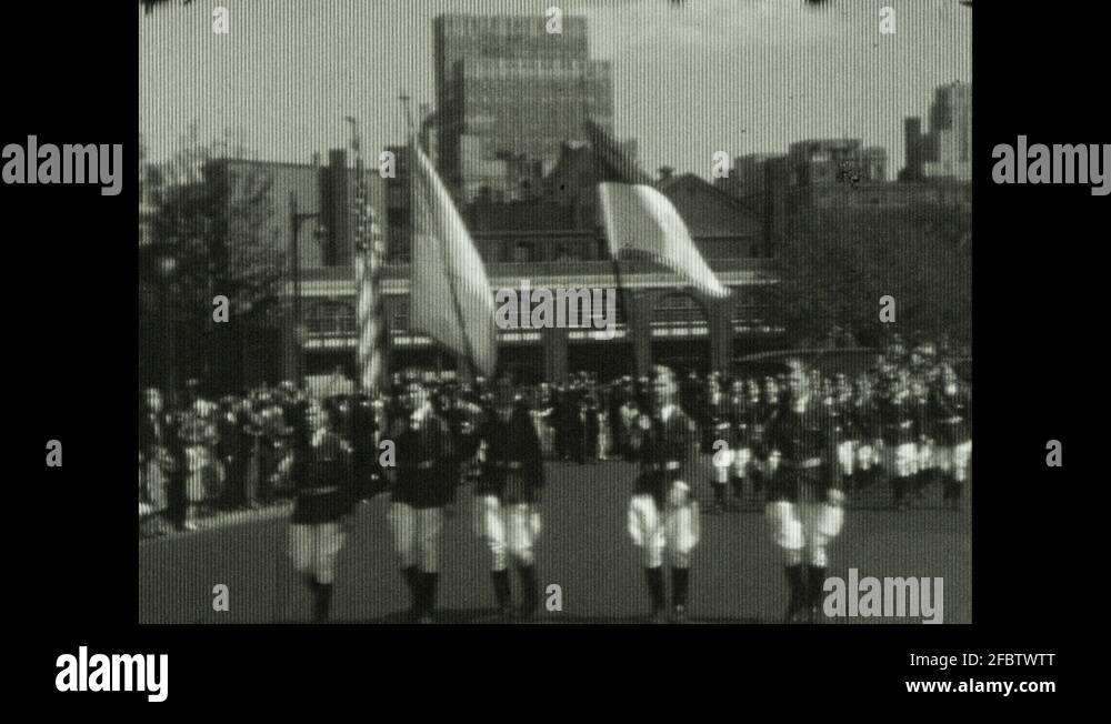 1930s: men in uniform marching in parade, two boys marching with banner ...