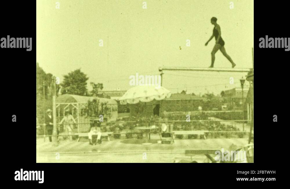 1930s: UNITED STATES: side view of lady diving into pool from high ...