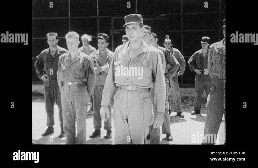 1950s: UNITED STATES: soldier speaks to guard. Fence around camp ...