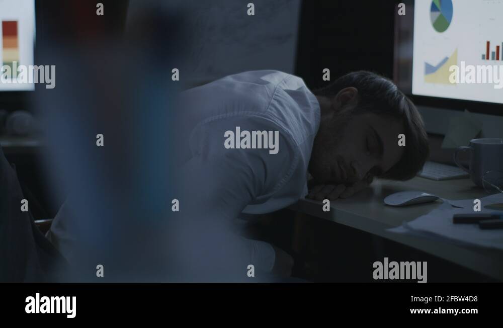 Tired business man sleeping on desk front computer screen in night ...