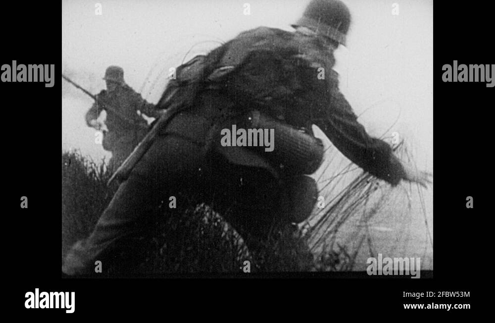 1940s: Nazi soldiers lay barb wire. Nazi officers talk around a table ...