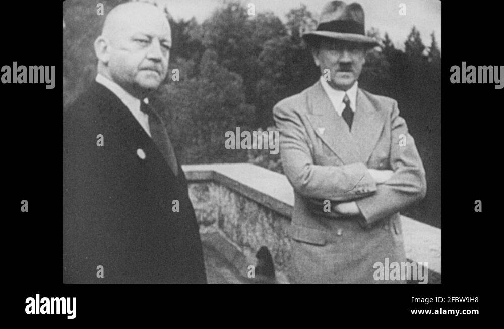 1940s: Adolf Hitler with crossed arms and fedora on veranda. Eva Braun ...