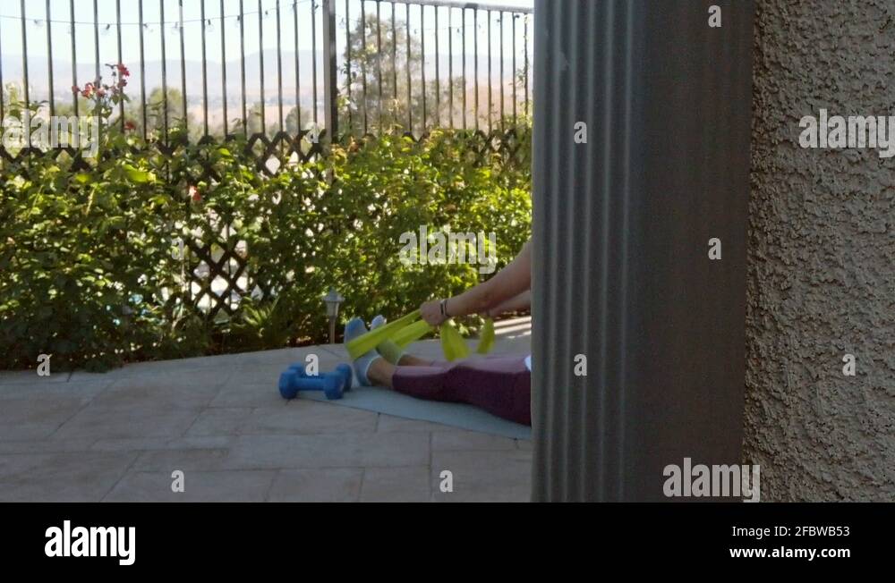 Dolly reveal shot to the left as a woman stretching, exercising on a ...