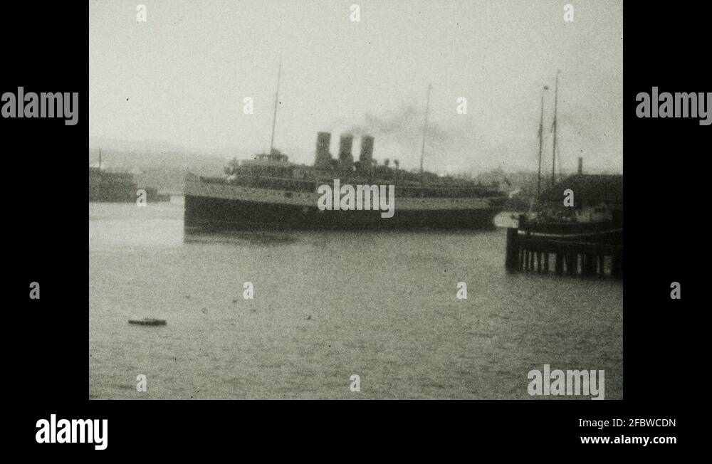 1920s: Ship pulls into port. People walk around city. People walk on ...