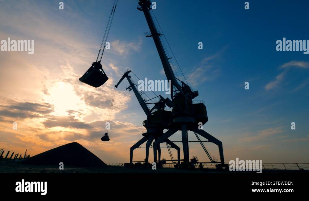 Dock cranes work with rubbles on a sunset background Stock Video ...