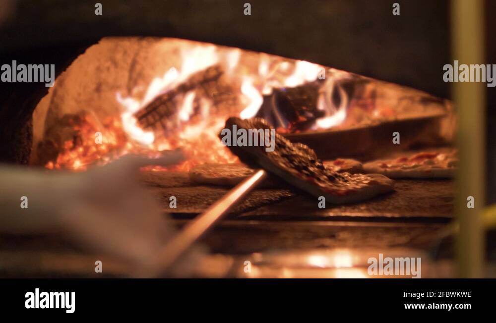 Cooking pizzas around a traditional Italian pizza oven. REAL TIME Stock ...
