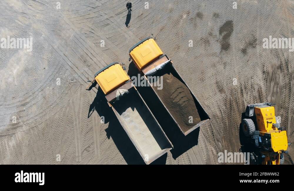 Working tractor load two trucks with crushed stone. Industrial mining ...